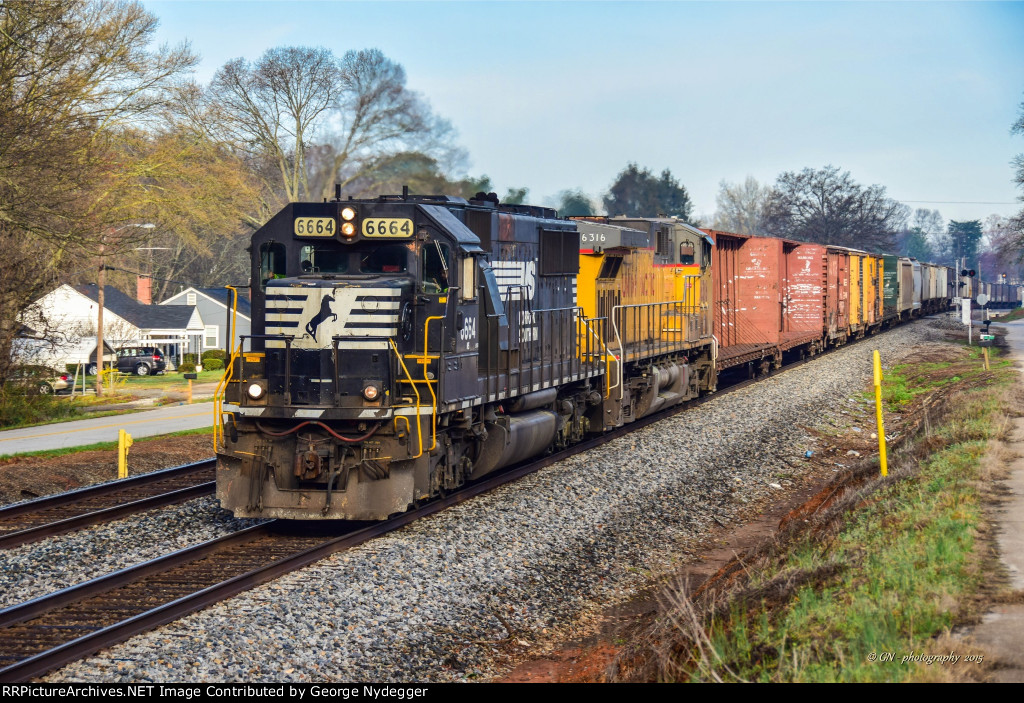 NS 6664 / SD60 is leading a mixed freight train